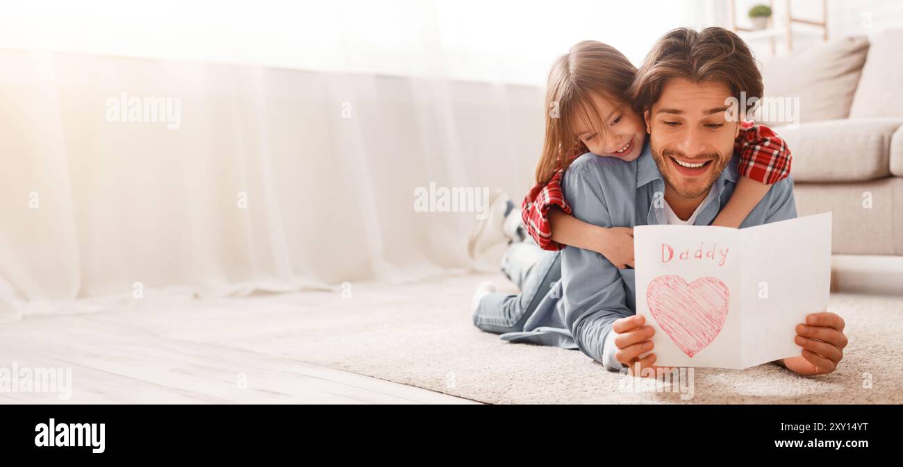 Emotional dad reading greeting card while bonding with daughter Stock ...