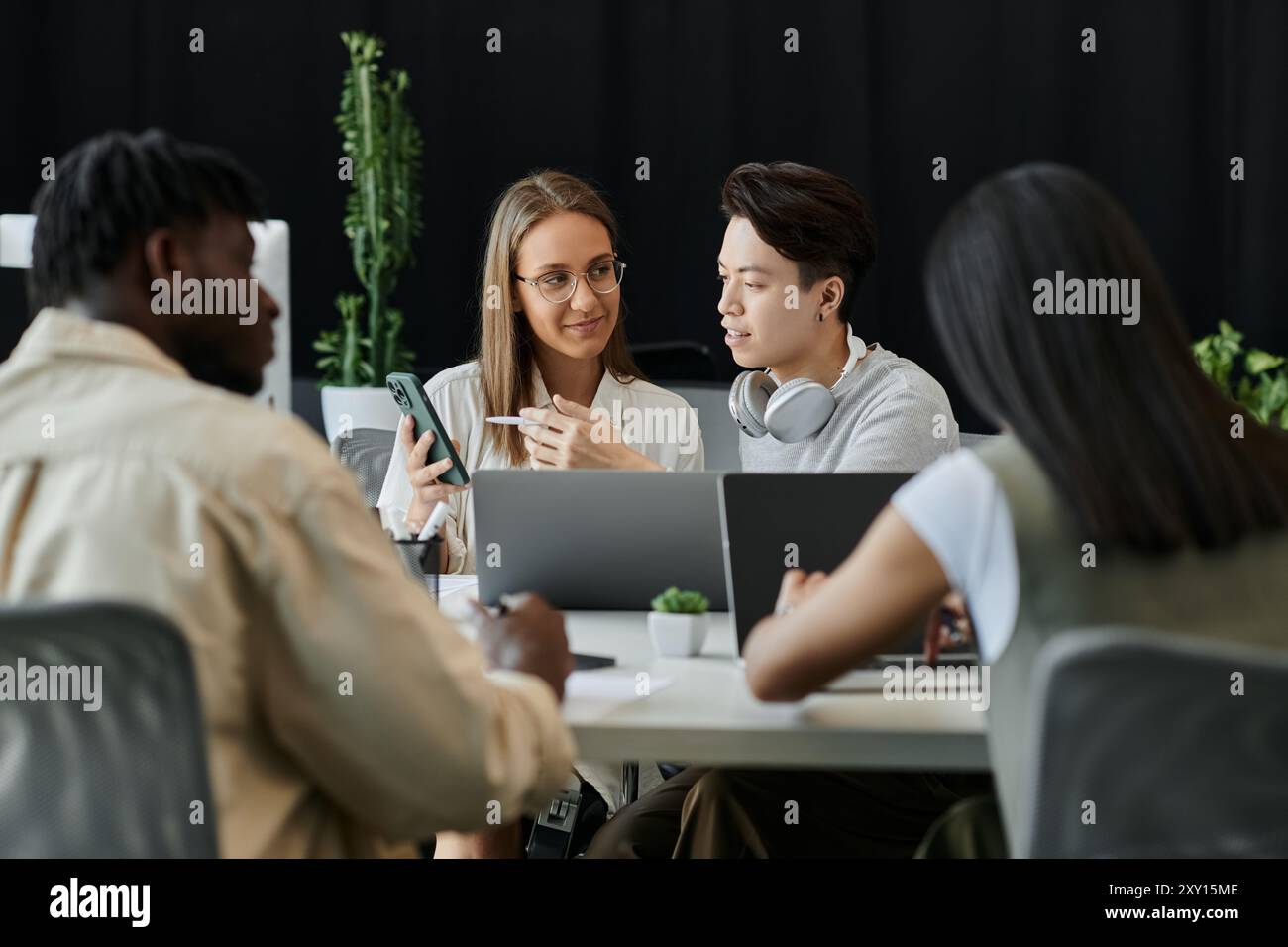 A group of four people work together on a startup project ...