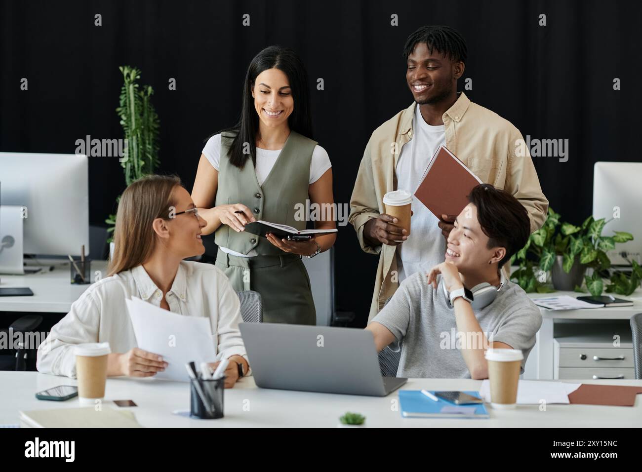 Four colleagues collaborate on a project in a contemporary office ...