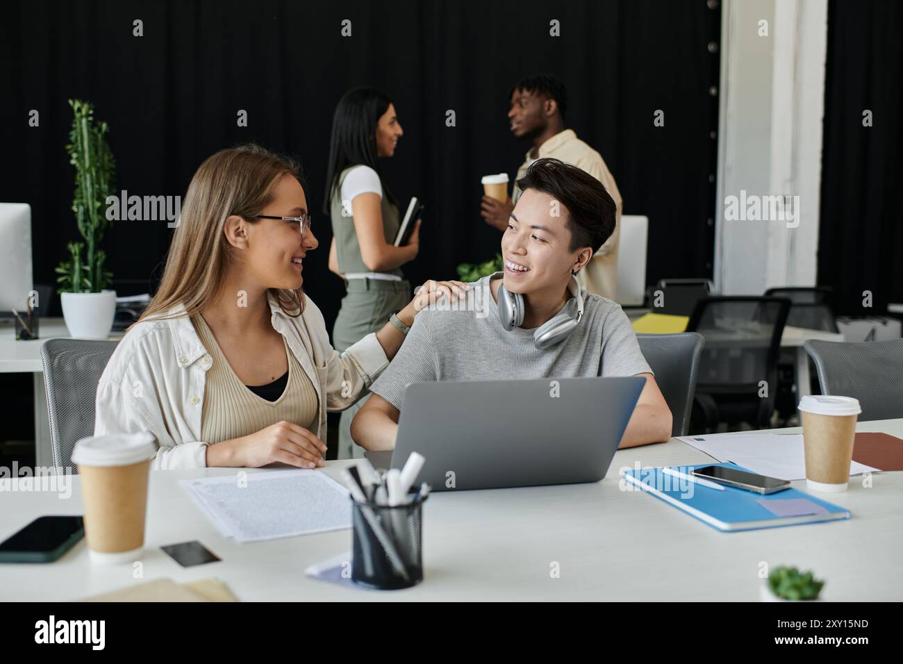 Two colleagues discuss ideas at a modern office desk Stock Photo - Alamy