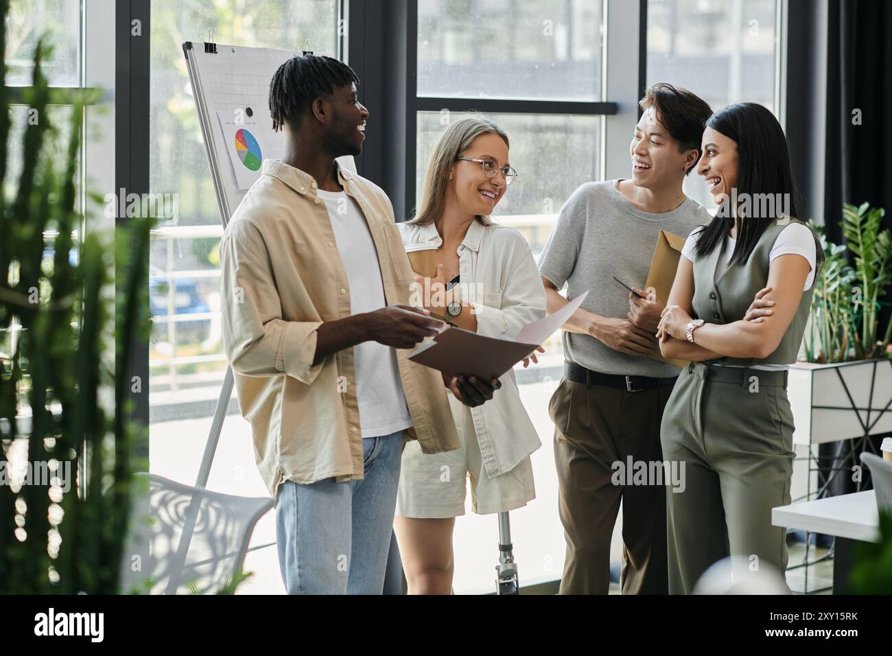 A diverse group of four individuals discuss ideas in a modern office ...