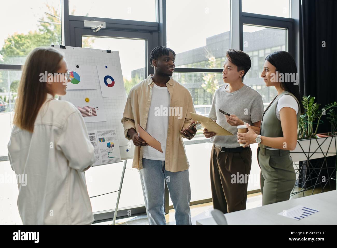 A group of colleagues huddle around a whiteboard, analyzing charts and ...