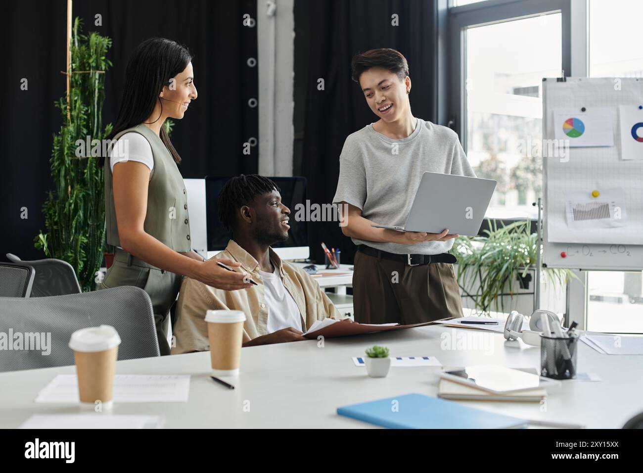 Three coworkers brainstorm ideas around a conference table Stock Photo - Alamy