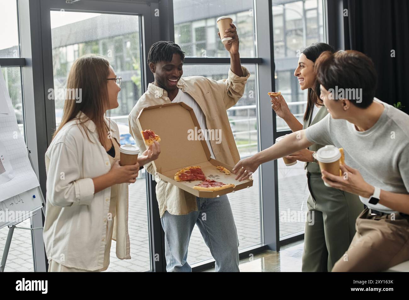 A team of coworkers enjoys pizza and coffee during a break in their busy workday Stock Photo - Alamy