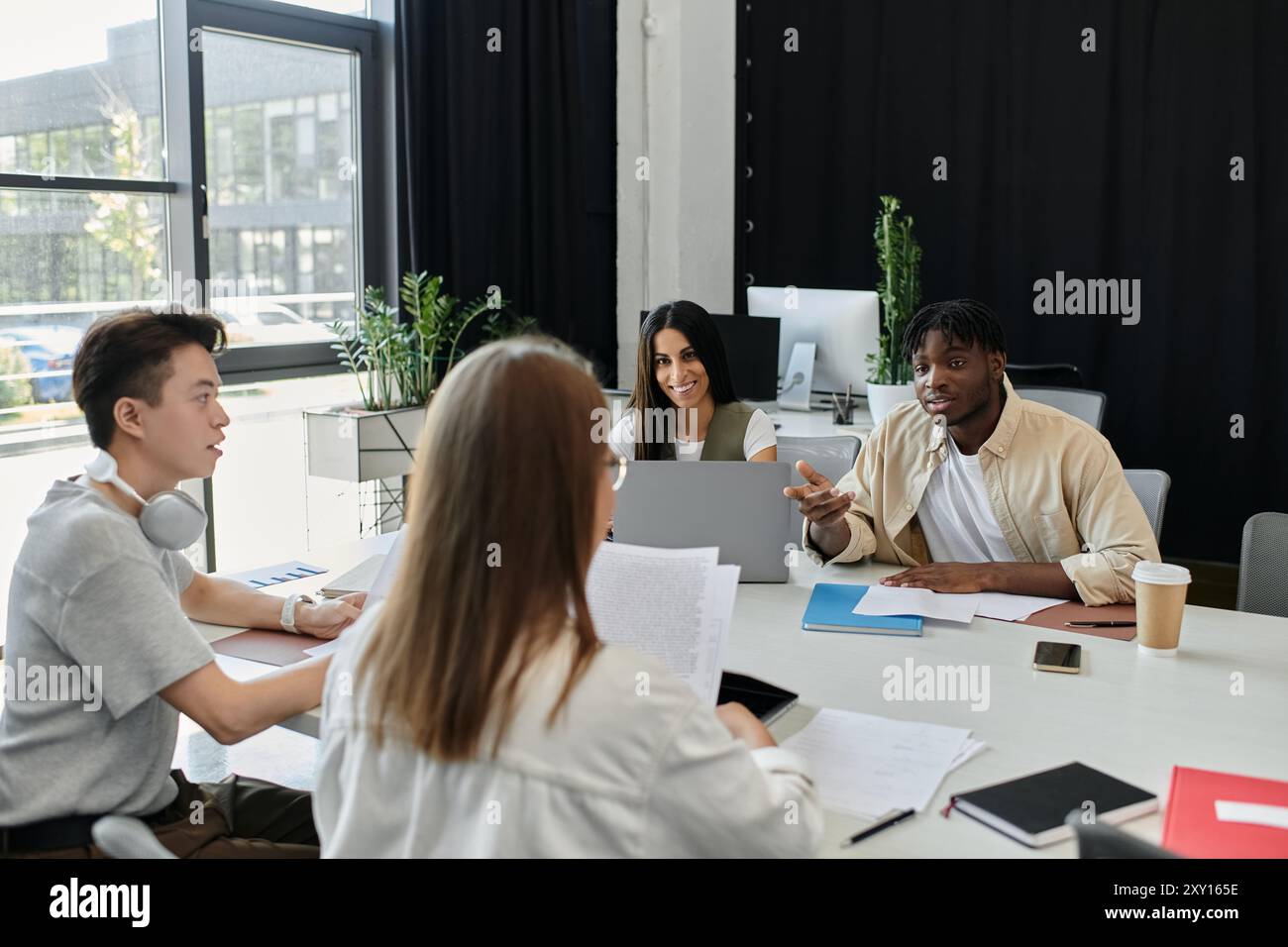 Four colleagues gather around table hi-res stock photography and images ...