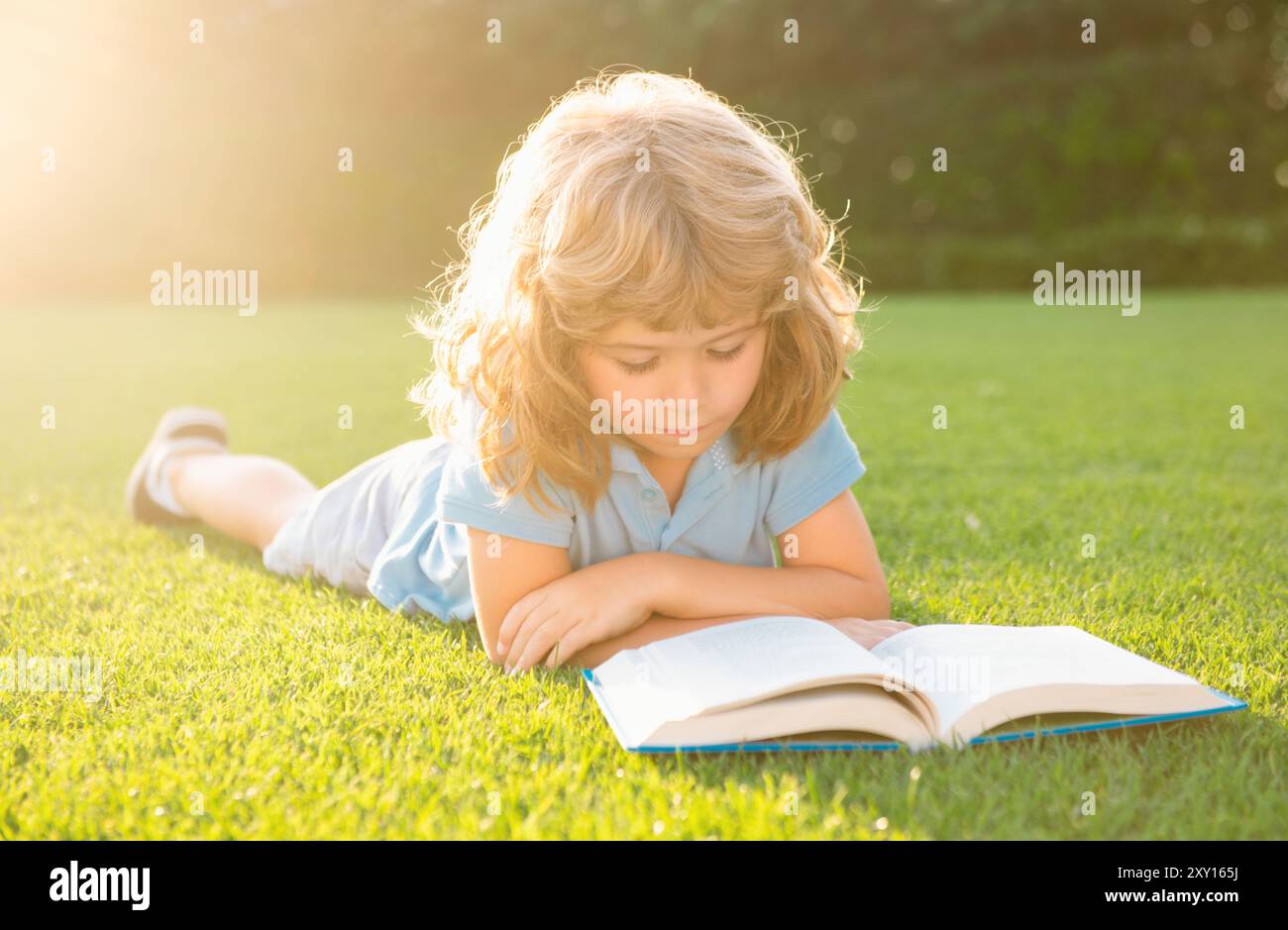 Smart clever Kids. Beautiful child boy book on grass background. Kids ...