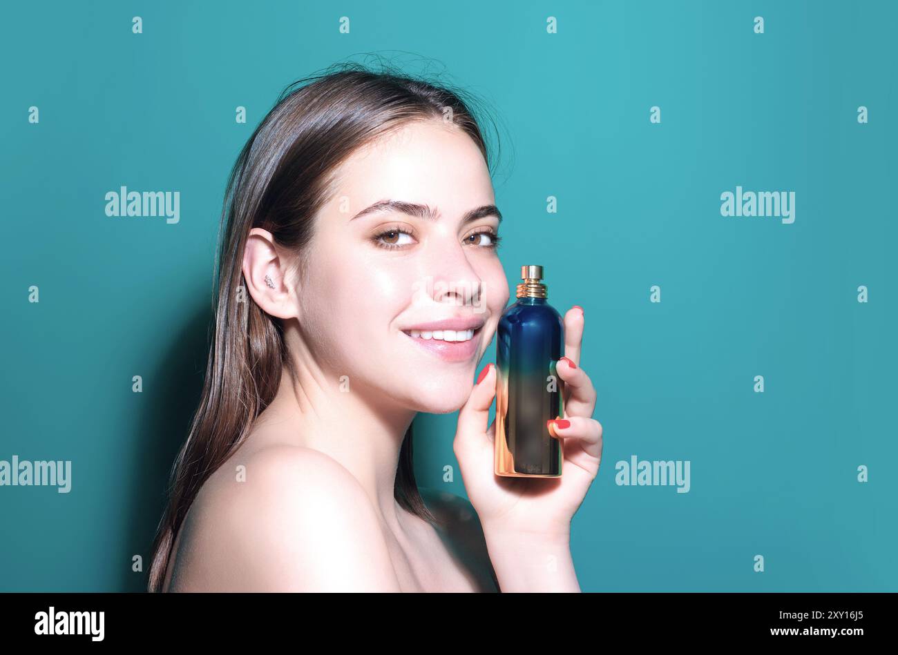 Woman with perfume bottle in studio. Girl with perfume, young beautiful ...