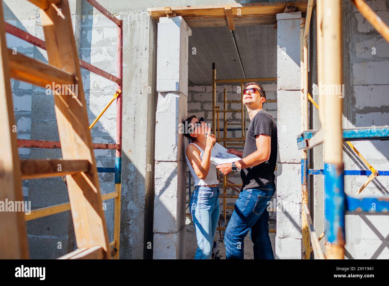 Young couple checking their future house under construction. Family ...