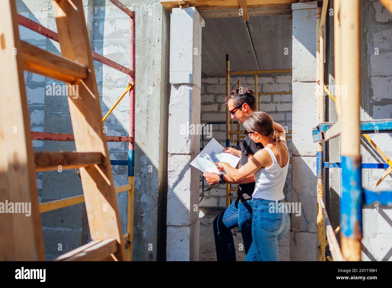 Young family couple checking their future house under construction ...