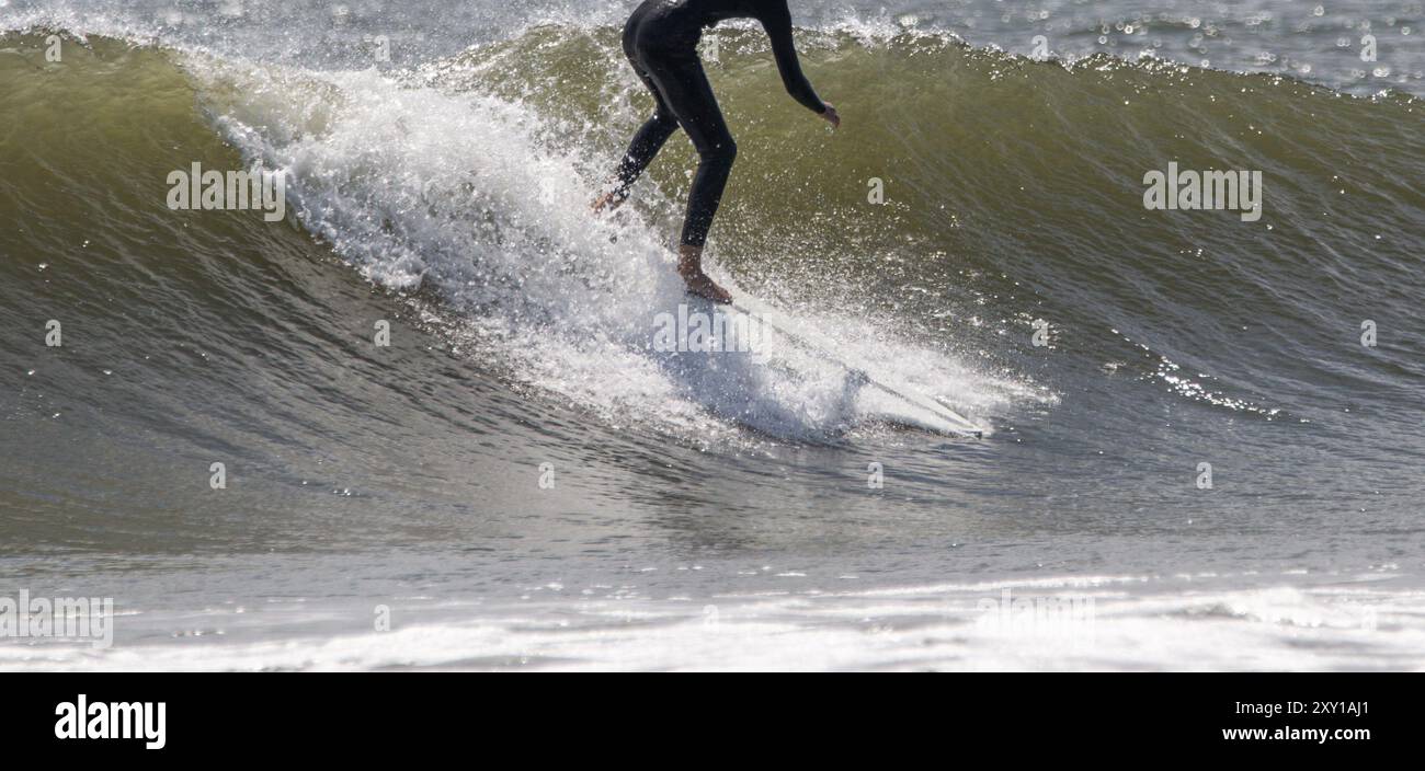 Man at the beginning of catching a wave while surfing in the Atlantic ...
