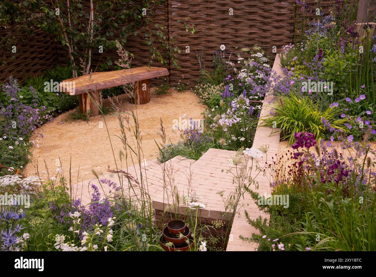Clay paver steps leading to a sunken seating area and wooden bench ...