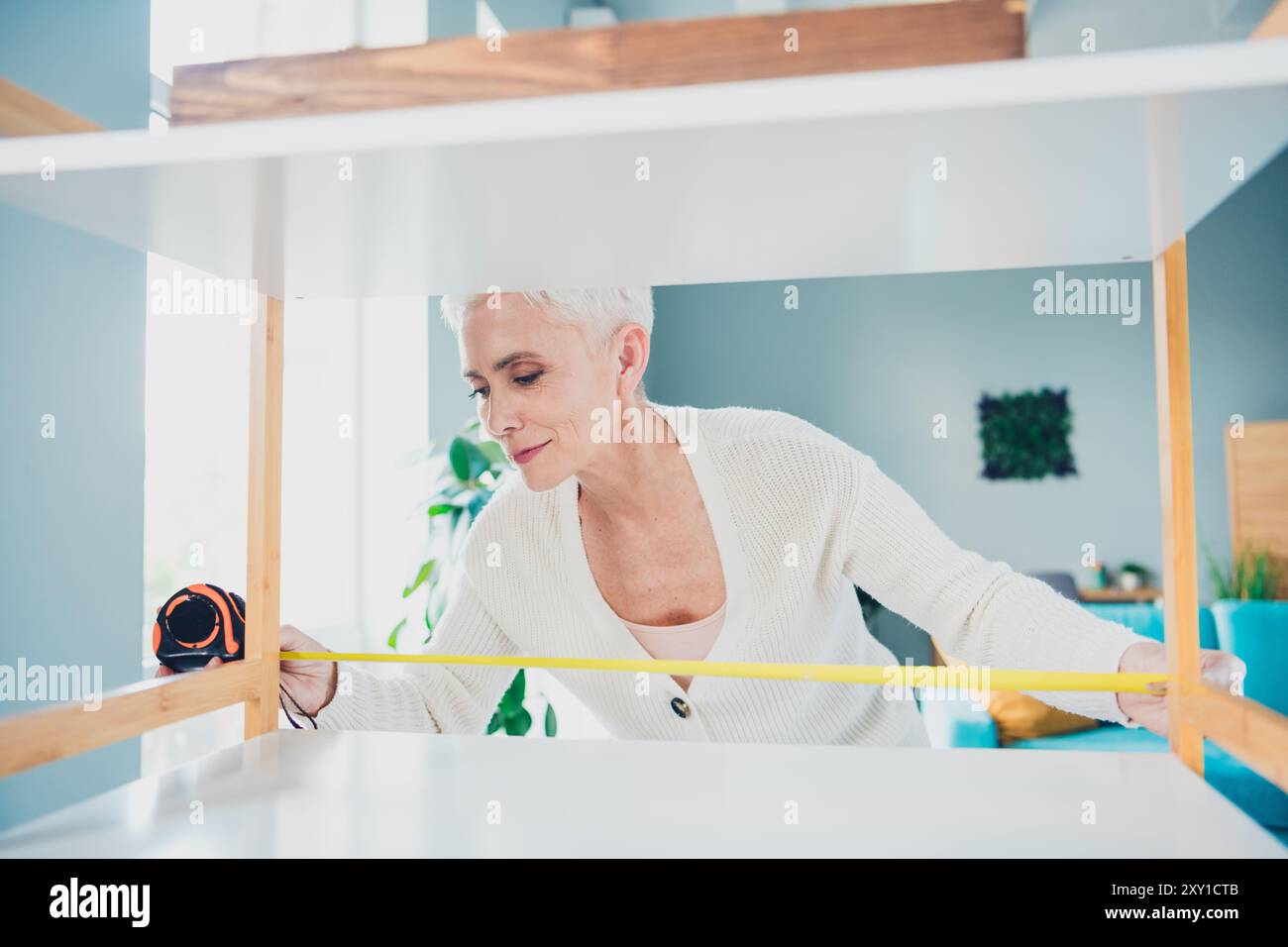 Photo of senior woman measuring with centimeter tape furniture size ...