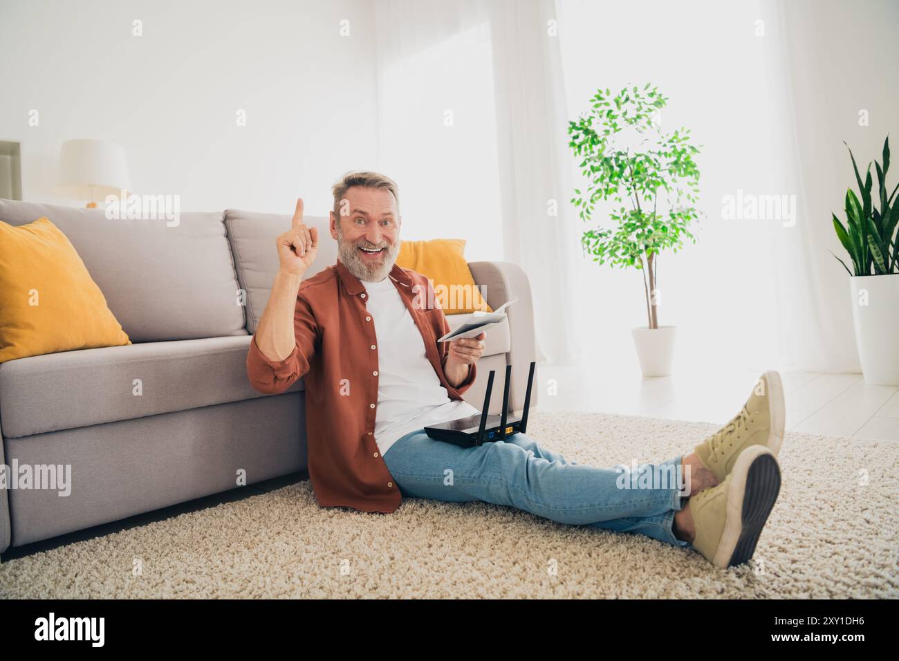 Full body photo of nice retired man sit floor excited read instruction ...