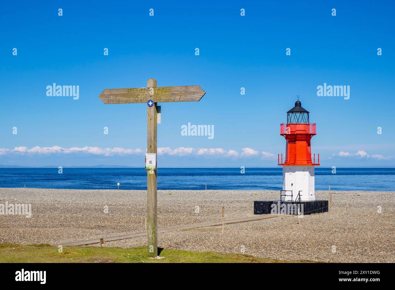 Coastal Path signpost and lighthouse on shingle beach on northern coast ...