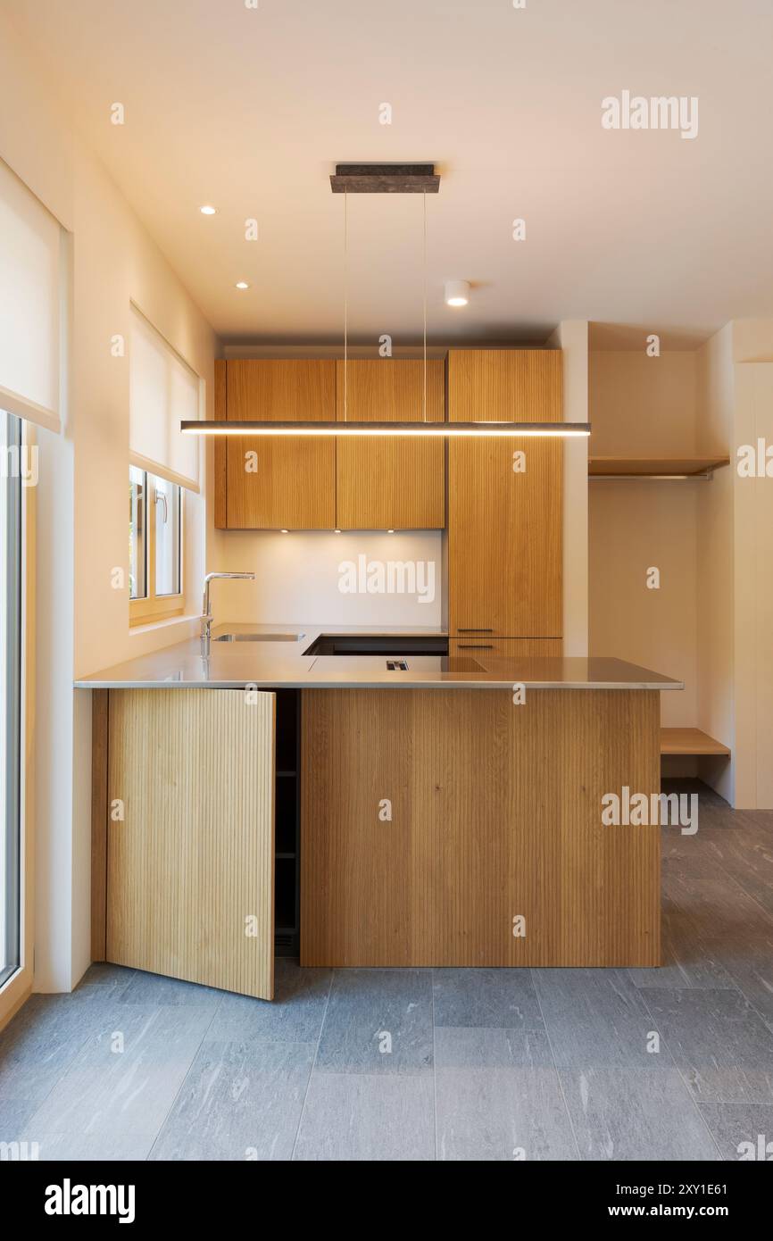 Front view of a modern wooden kitchen with an open door and an ...