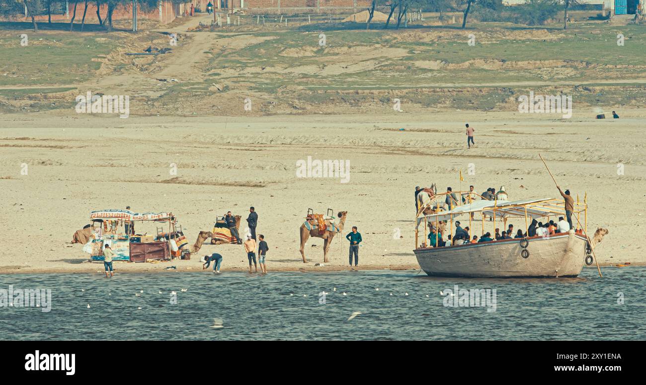 Varanasi, India. Boat With Pilgrims Moored To Shore. Many Seagulls Swim ...