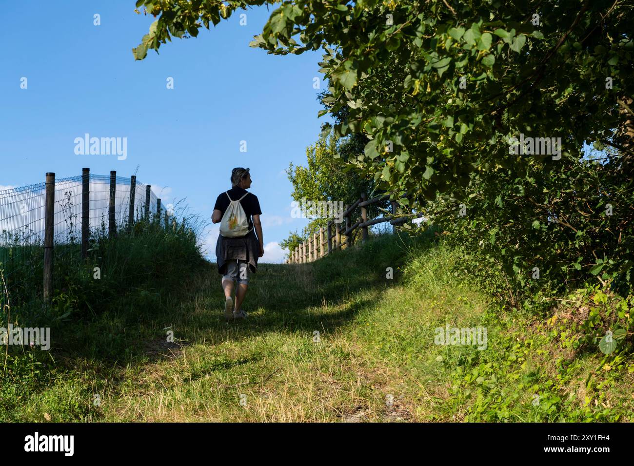 Woman strolling on grassy trail hi-res stock photography and images - Alamy