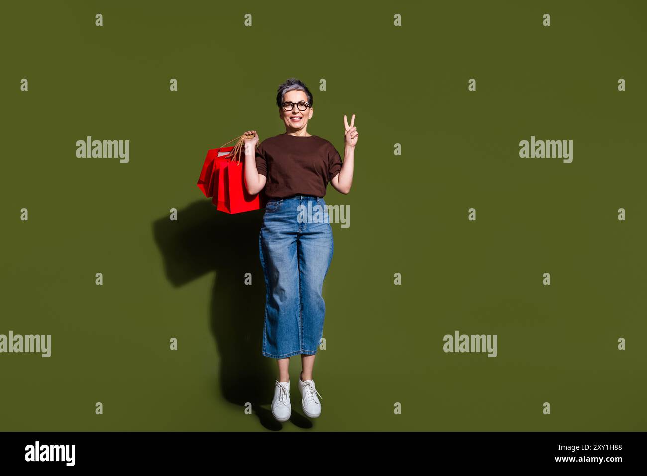 Full size photo of nice aged woman jump bags v-sign wear t-shirt ...