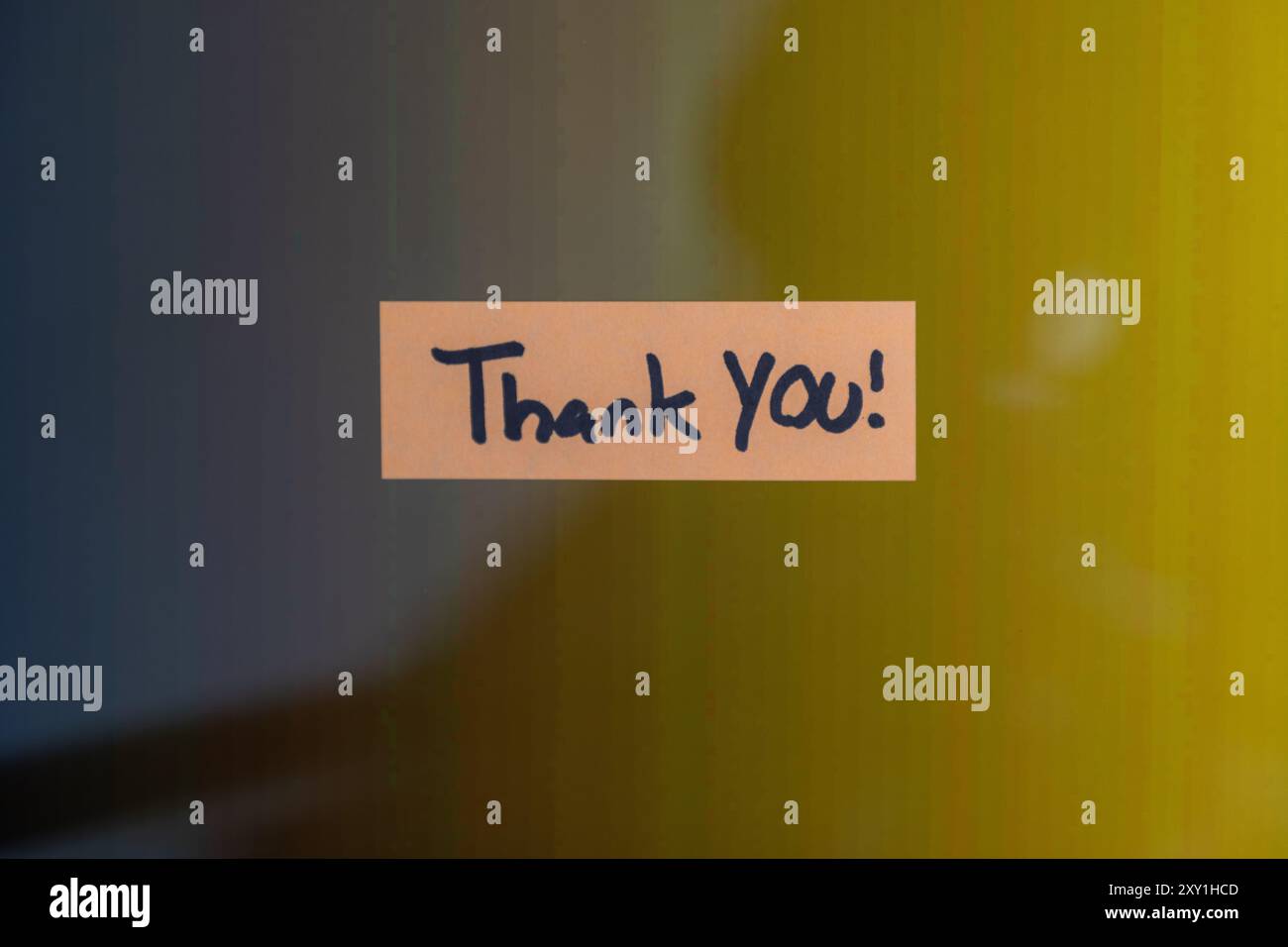 A thank you note stuck to a digital computer screen fading from black ...