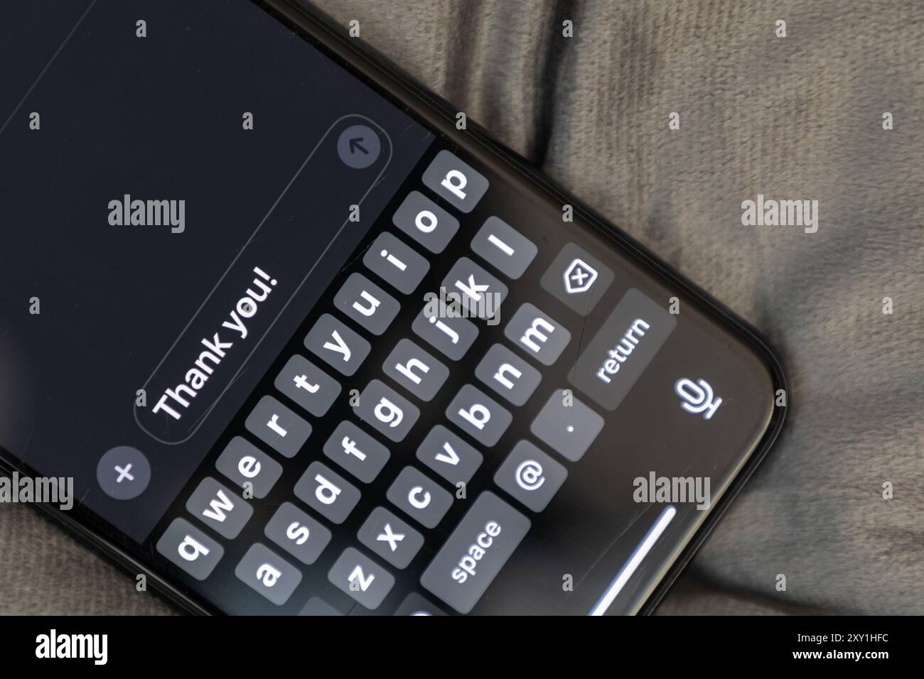 A phone with a keyboard on it that says "thank you" on it ready to send ...