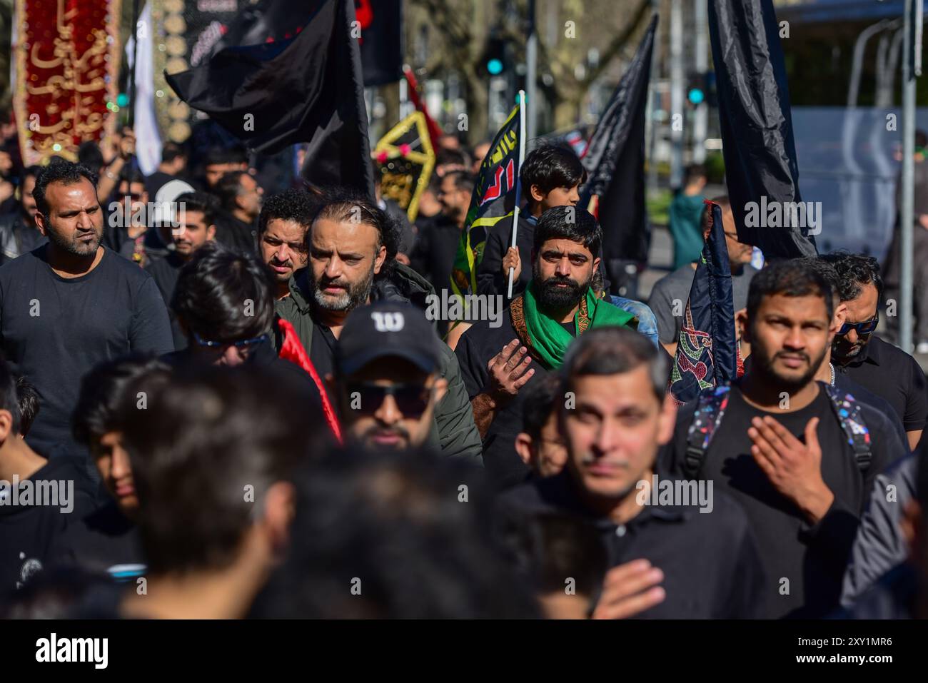 Shia men wearing black are seen during Arbaeen procession. The 16th ...