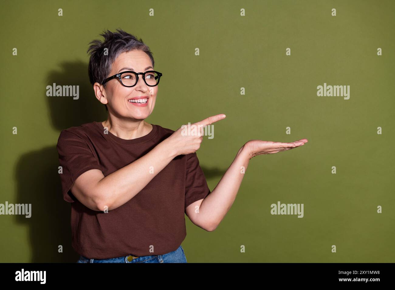 Photo portrait of pretty senior female hold point look empty space wear ...