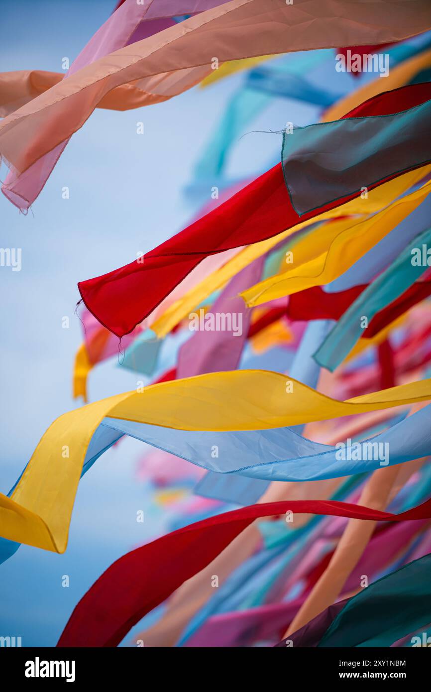 Color image of many colorful ribbons blown by the wind, against a blue ...