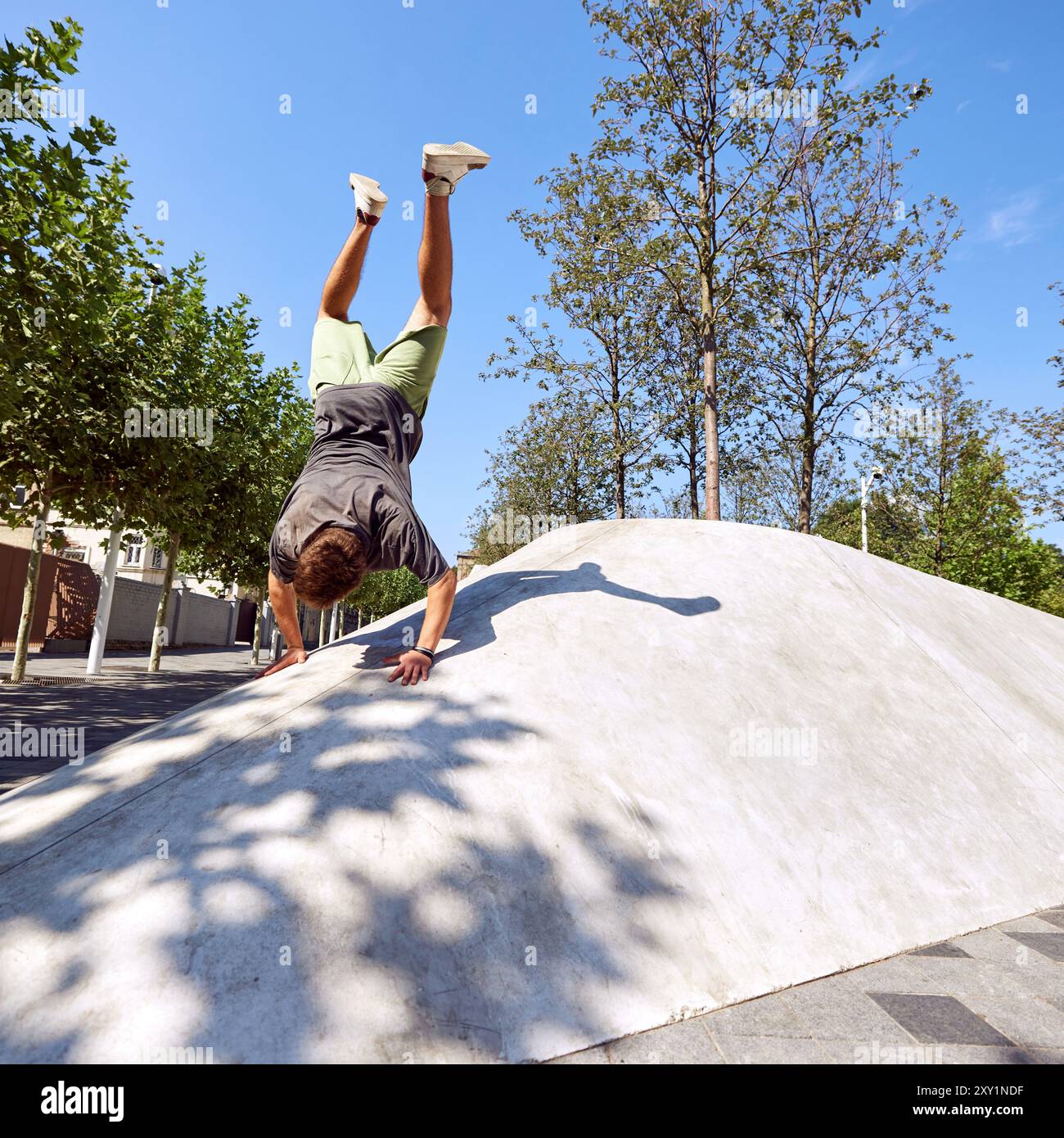 Young sports man doing perfect handstand on curved urban structure ...