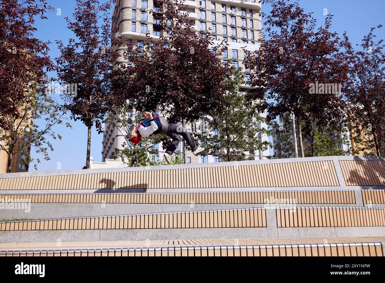 Dynamic image of athletic young man in red cap performing backflip on ...