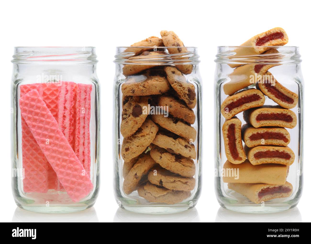 Three glass jars filled with cookies, on a white background with ...