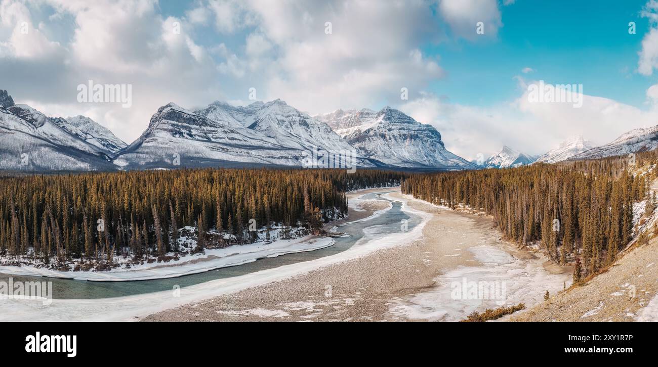 Winter landscape of rocky mountains and frozen fiver in pine forest at ...