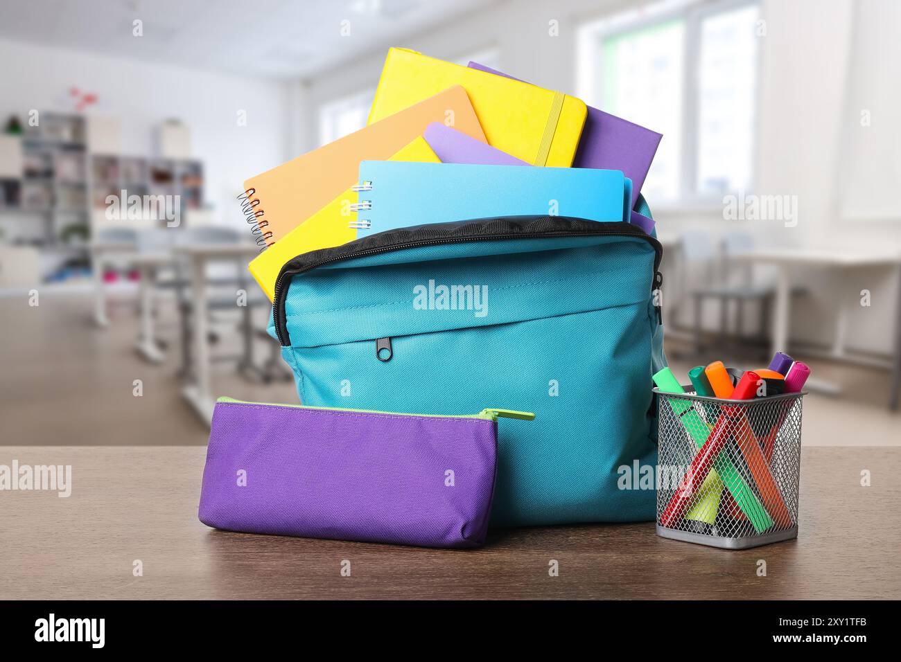 Light blue backpack with stationery on school desk in classroom Stock ...