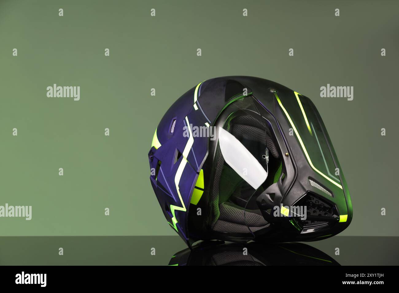 Modern motorcycle helmet with visor on mirror surface against grey ...