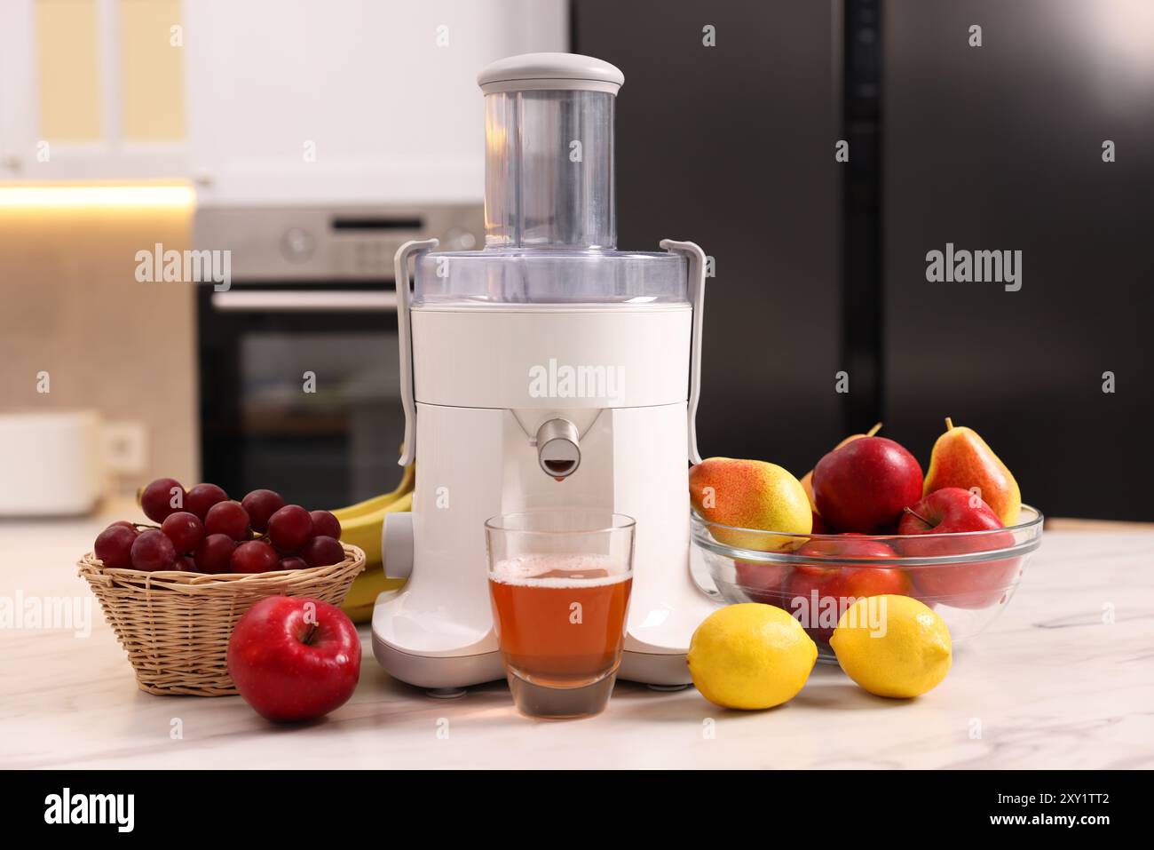 Modern juicer, fresh fruits and glass on white marble table in kitchen ...