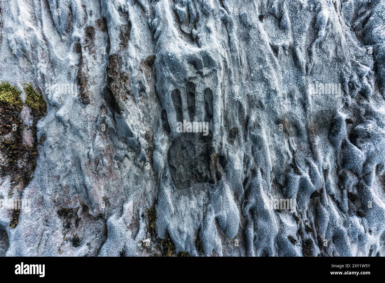 Aged of caveman palm hand print on limestone wall in ice cave on winter ...