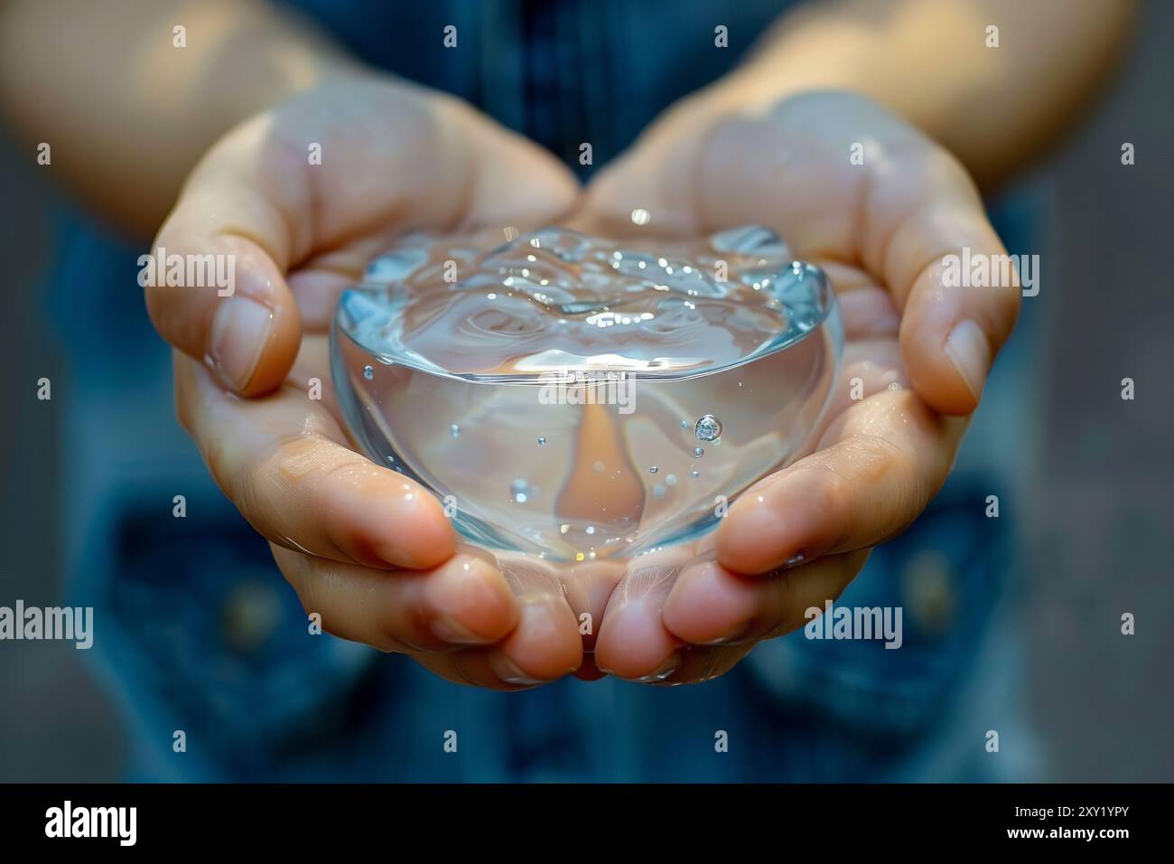 Hands cupped together holding clear water, save water, clean renewable ...
