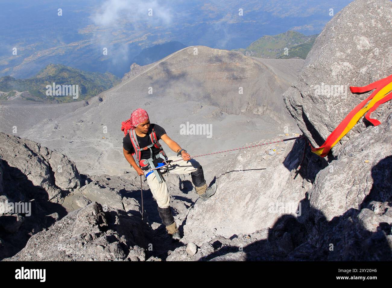 A climber descends lava rock on the peak wall of Merapi by using a ...