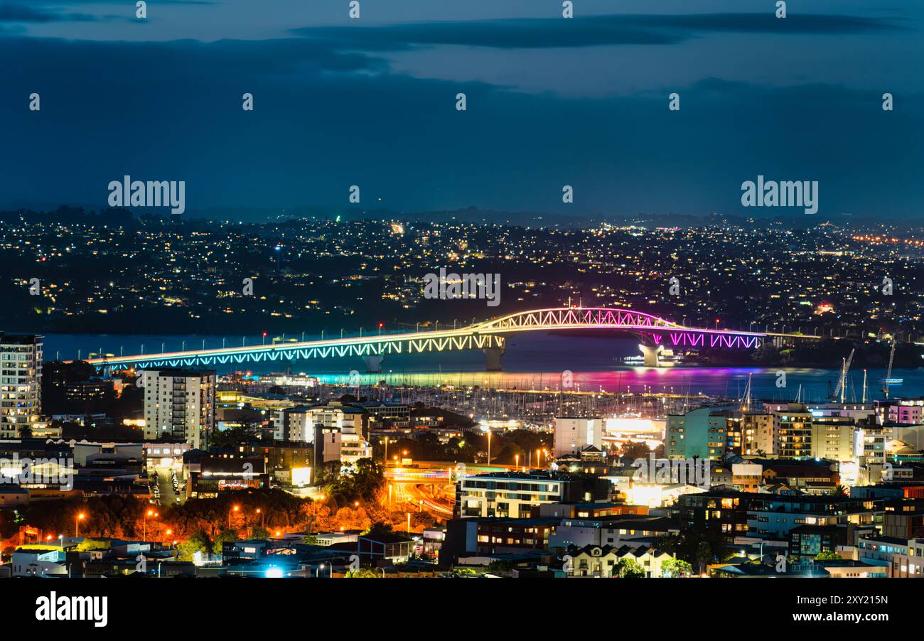 Illuminated rainbow color bridge crossing over the sea by the Auckland ...