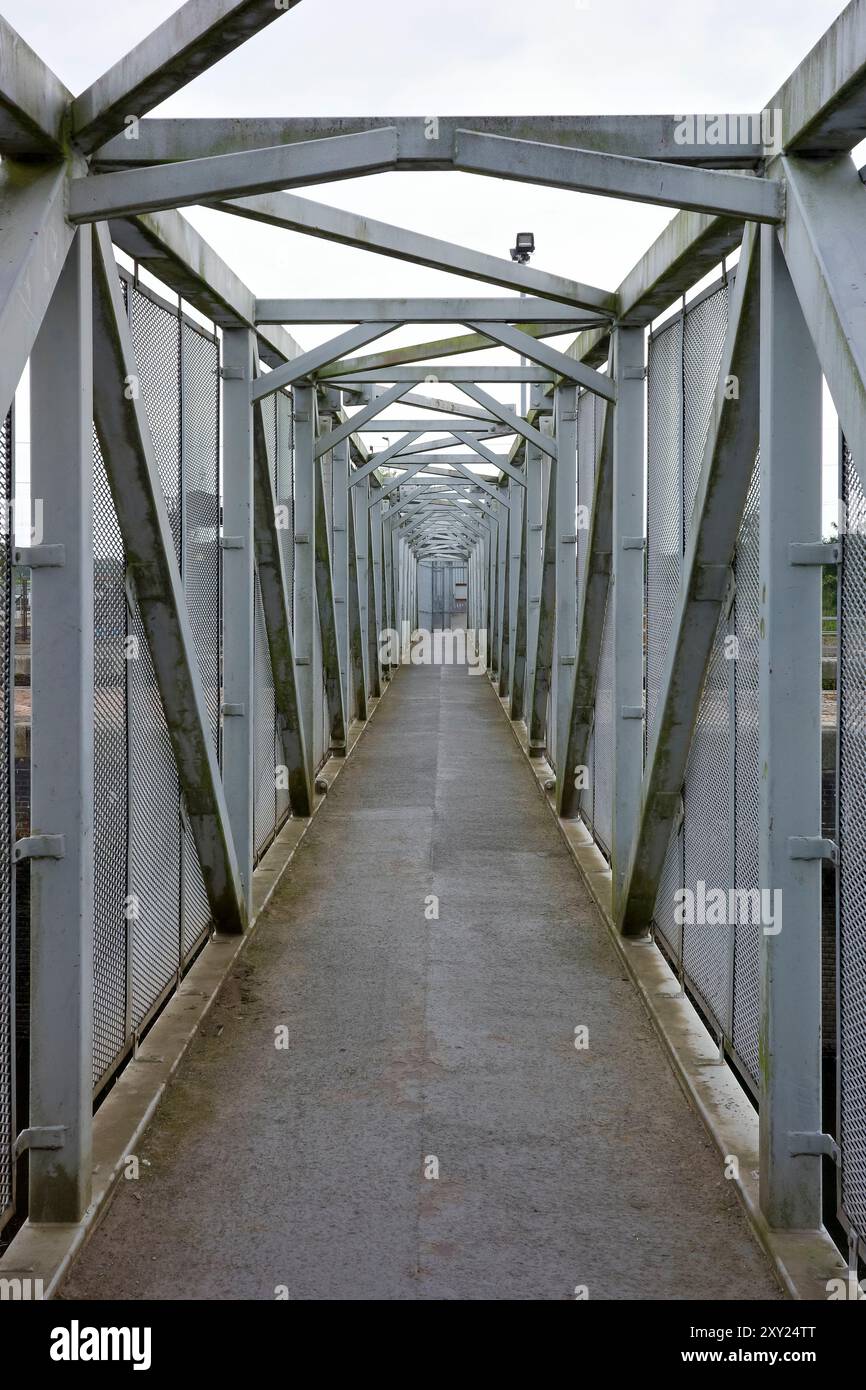 Metal pedestrian bridge footpath with geometric framework captured on a ...