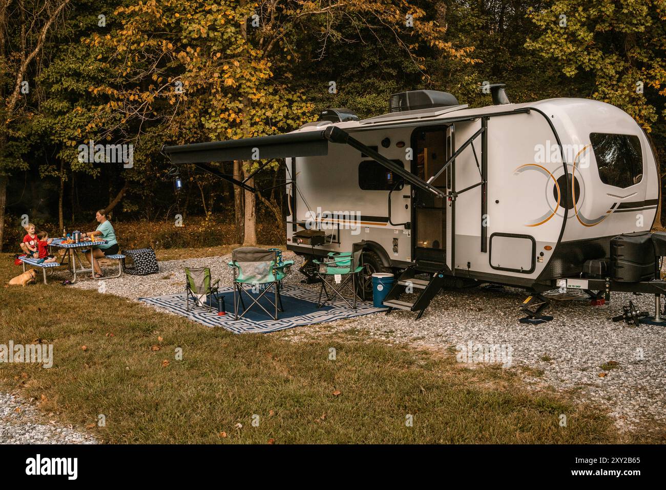 Family Enjoying Vacation at Campsite Picnic Table with Travel Trailer ...