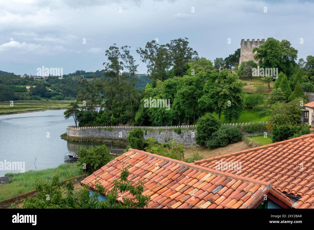 Nestled among vibrant trees and rustic homes, the impressive Castle of ...