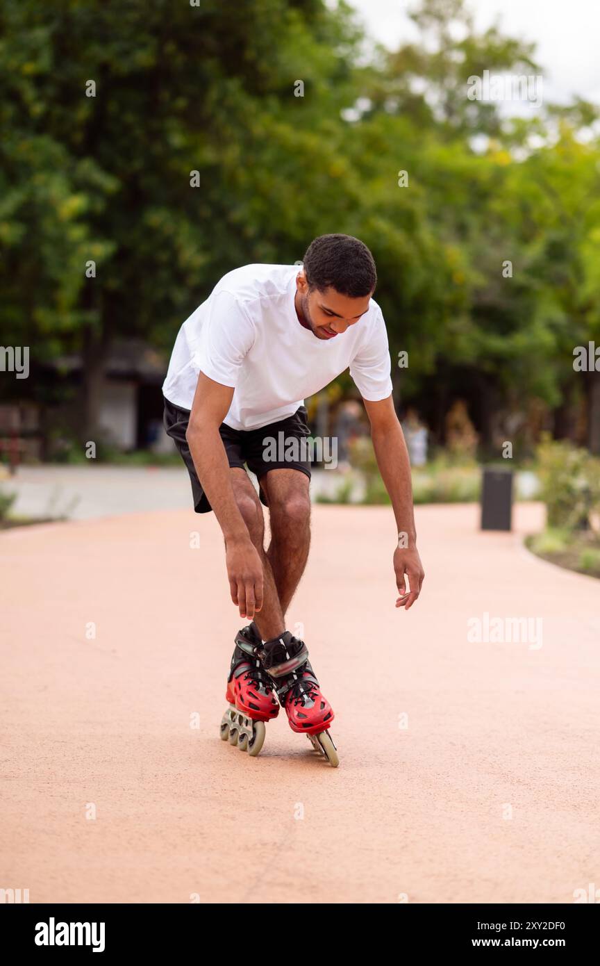 Tall dark-haired young man on rollers in the park having a ride Stock ...