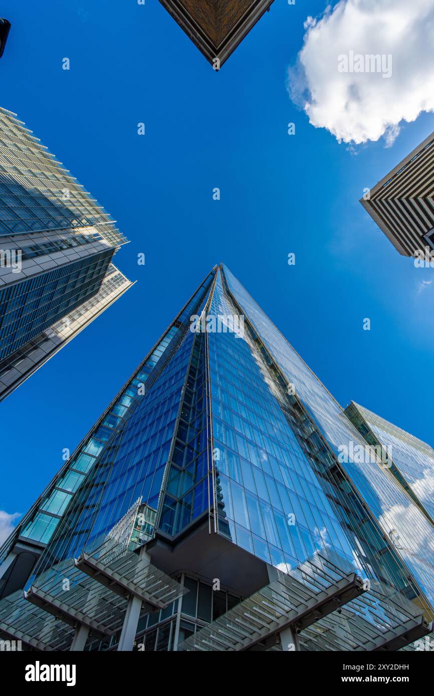 Low angle view of a modern pyramid-shaped blue glass skyscraper ...