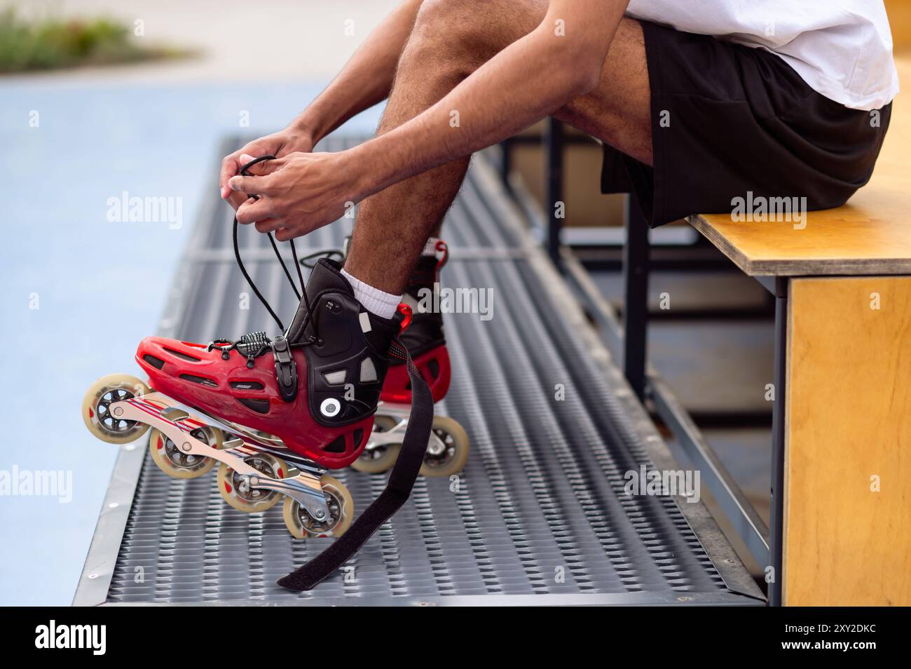 Man sitting on the bench and putting on rollers Stock Photo - Alamy