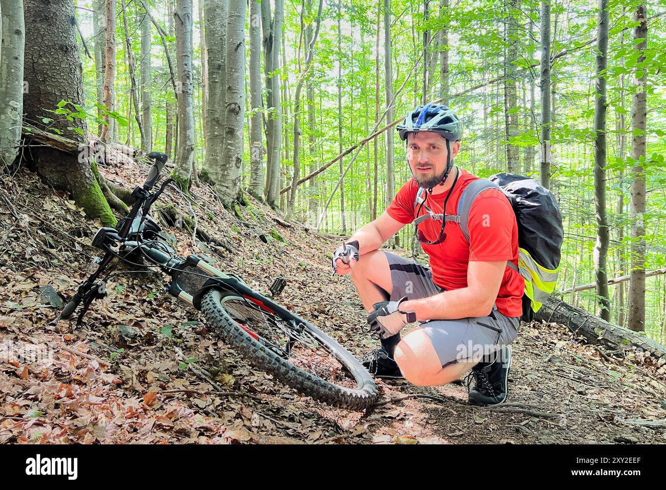 Portrait of man pumping bicycle wheel. Cyclist inflates bicycle wheel ...