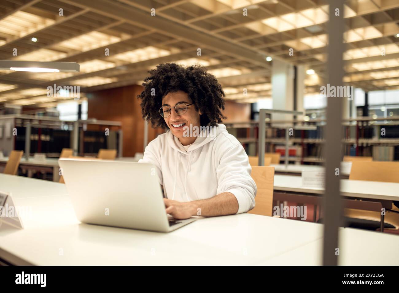 Man studying with computer preparing for exams in high school library ...