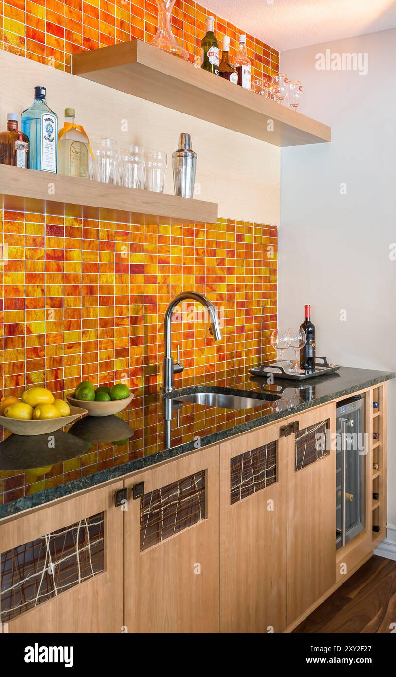 Bar with open shelves and colorful orange glass tile backsplash Stock ...