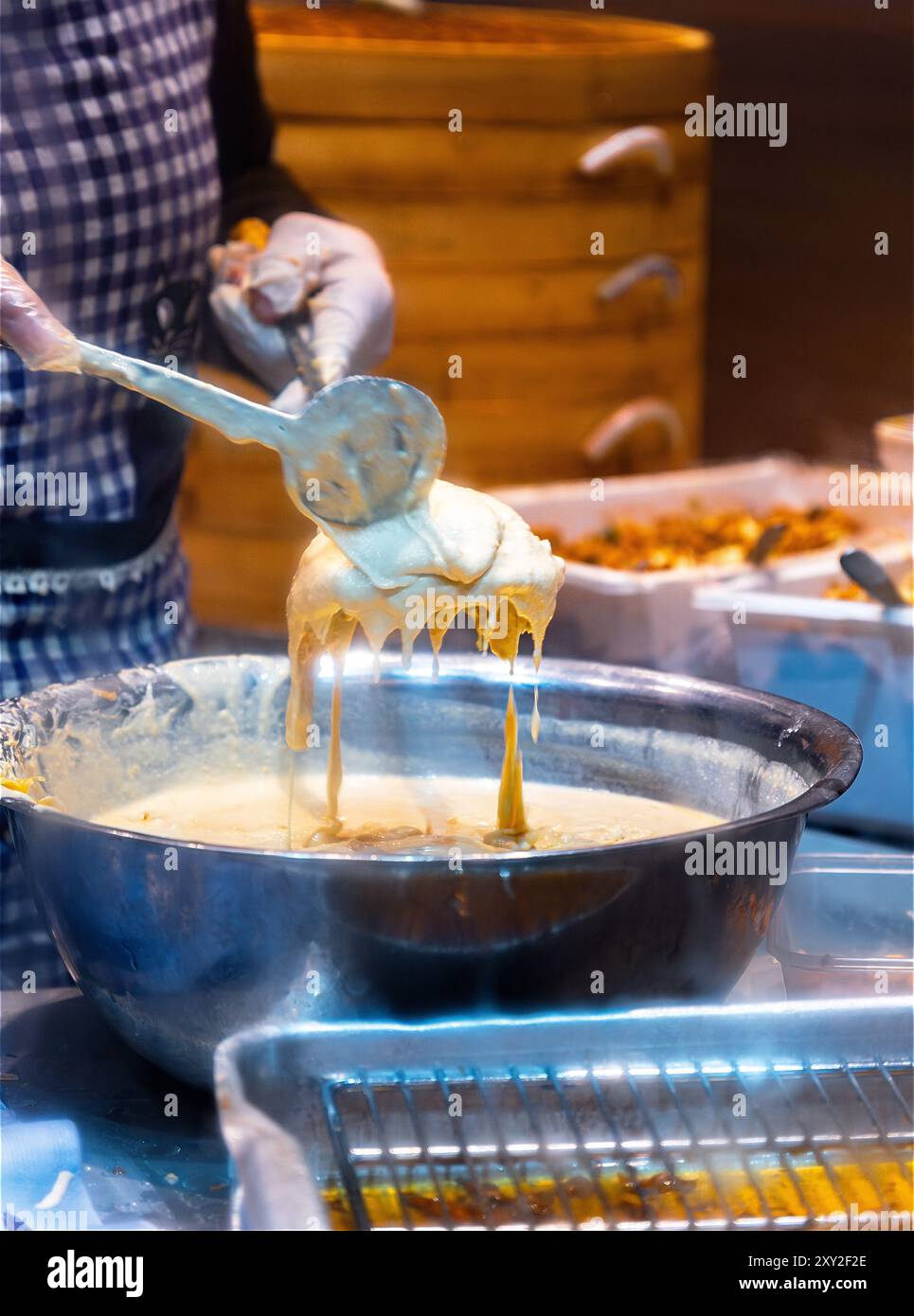 Chinese female chef in apron cooking dough to make dumplings with ...