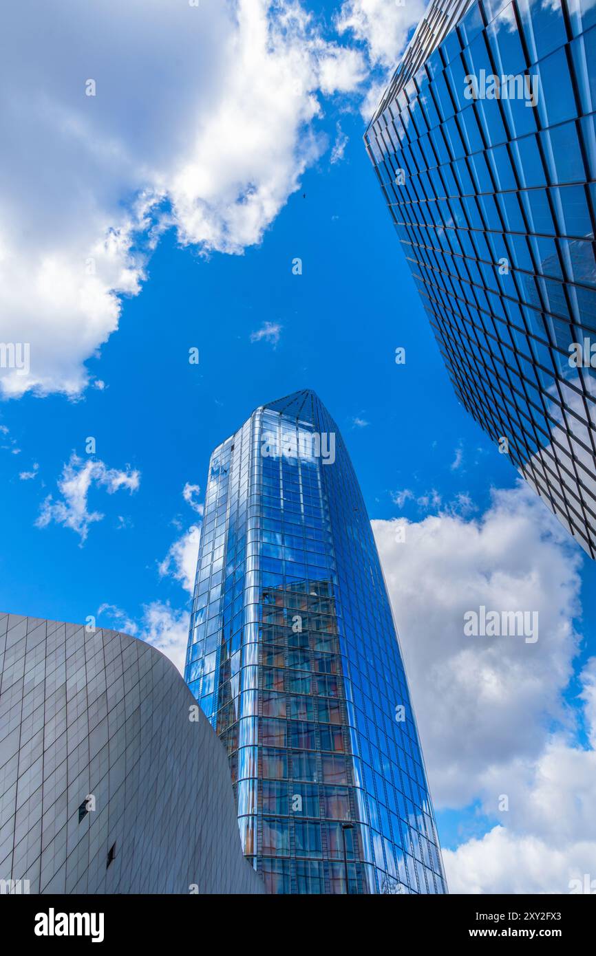 Low angle view of modern blue glass skyscraper with clear blue sky with ...
