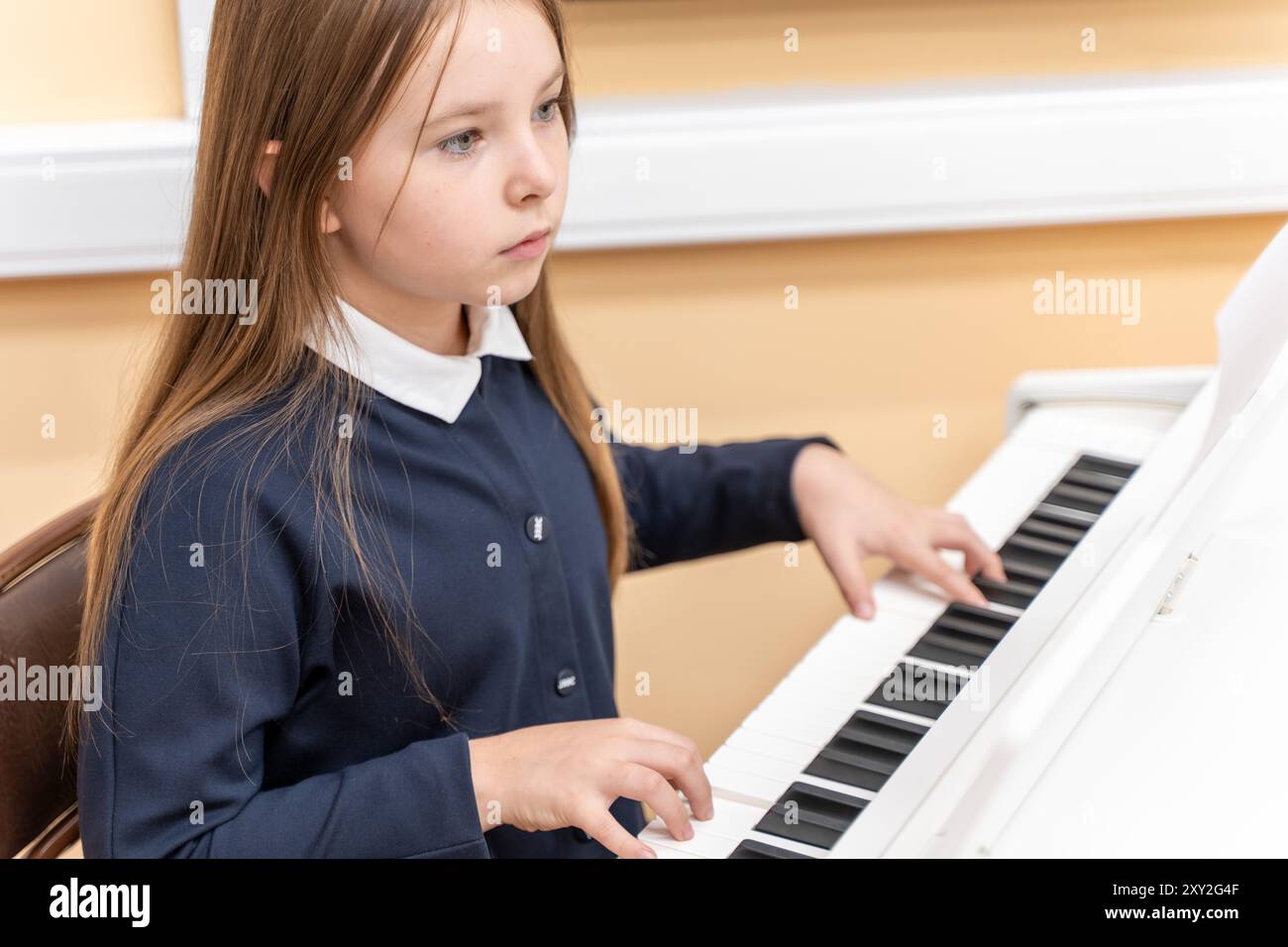 Little preteen girl plays the piano. Lesson at a music school. Music ...